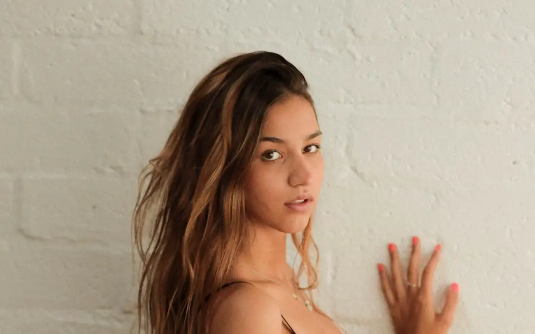 Mikaela Fuente en lencería negra frente a una pared blanca - ColorMusic