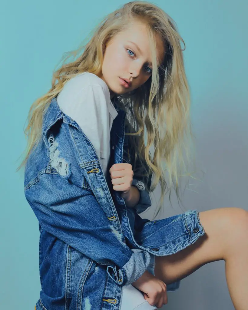 Amiah Miller con chaqueta de mezclilla en fondo azul - ColorMusic