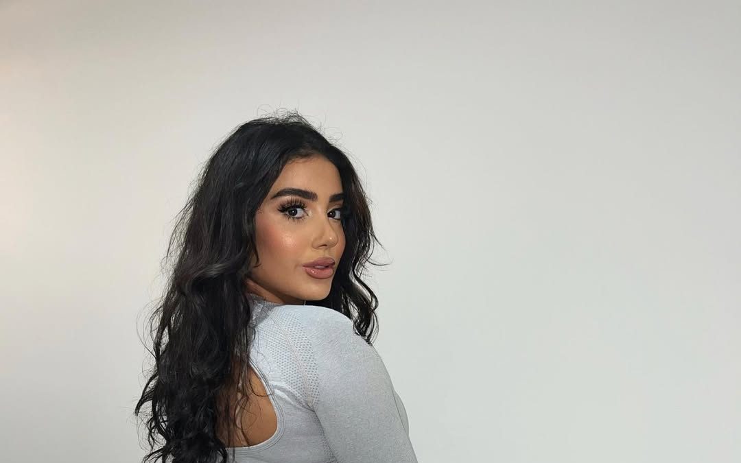 Mary Yousefi con conjunto gris junto a una chimenea - ColorMusic