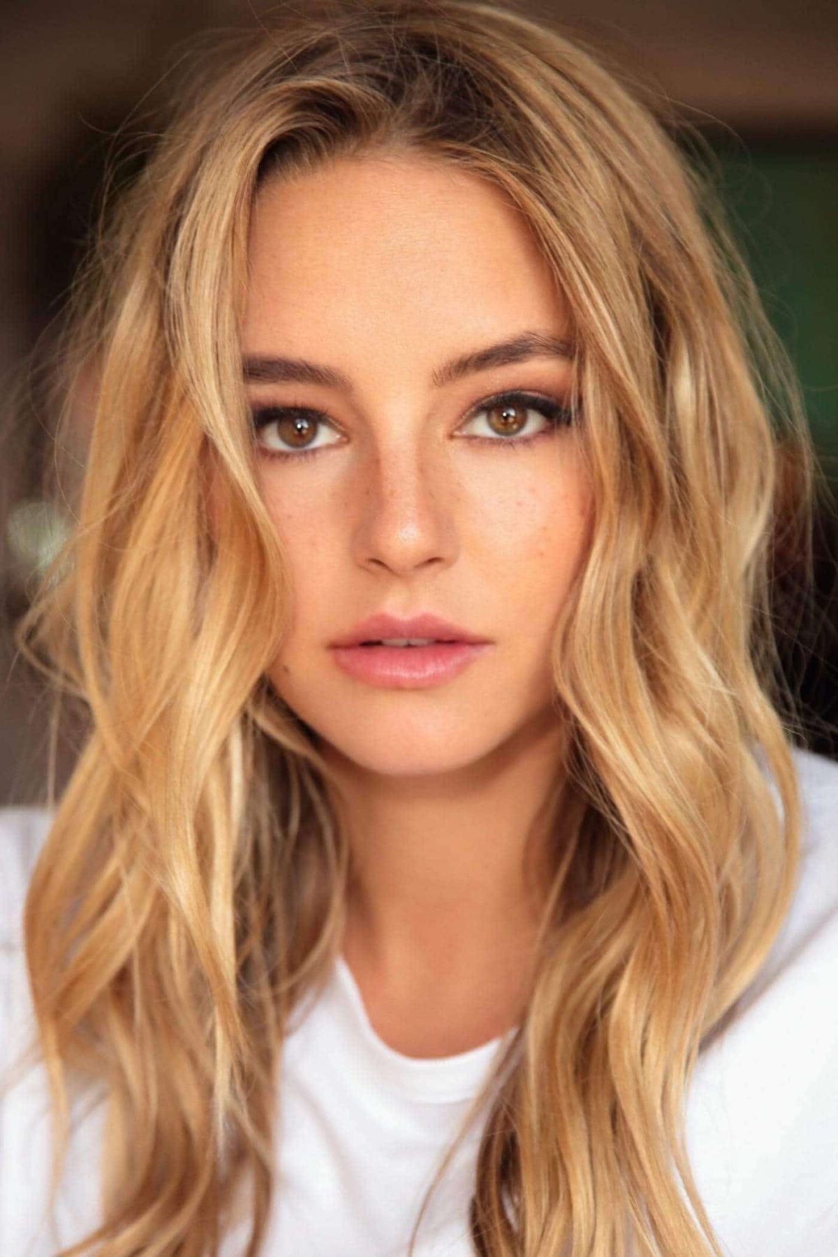 Hassie Harrison en blusa blanca: retrato natural con ondas doradas y ...